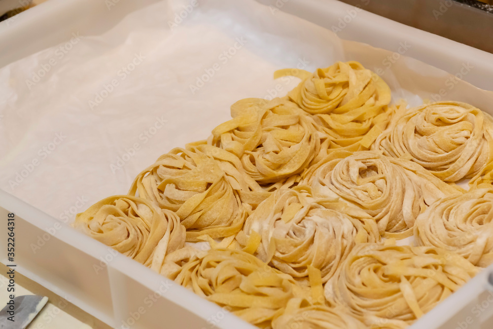 A half full white plate of freshly hand made plain floury pasta ...