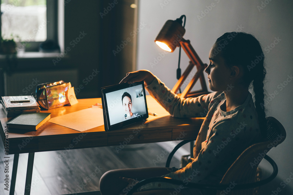 School girl having video call with teacher using webcam at home. Online ...