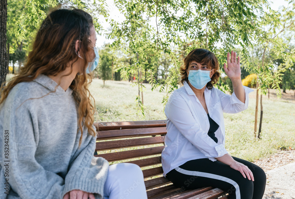 Social distance. Mother and daughter in social distance sitting on a ...