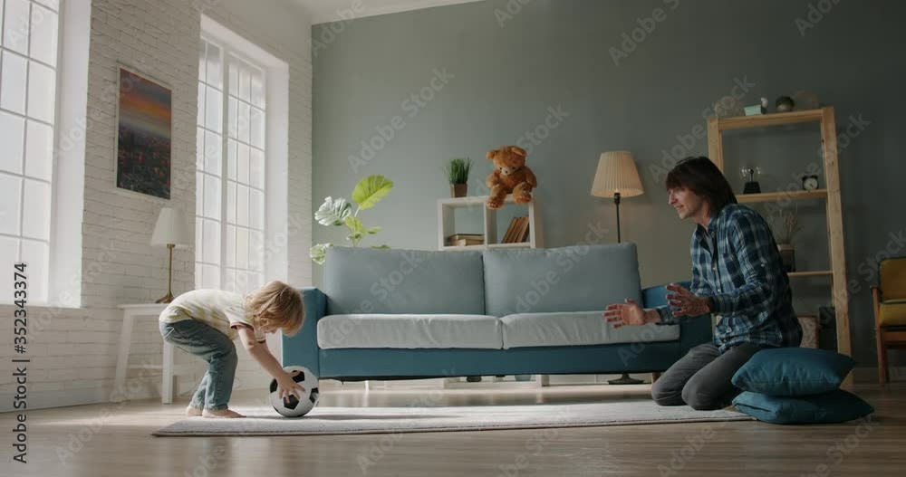 Funny father and son playing football at home. Little caucasian kid ...
