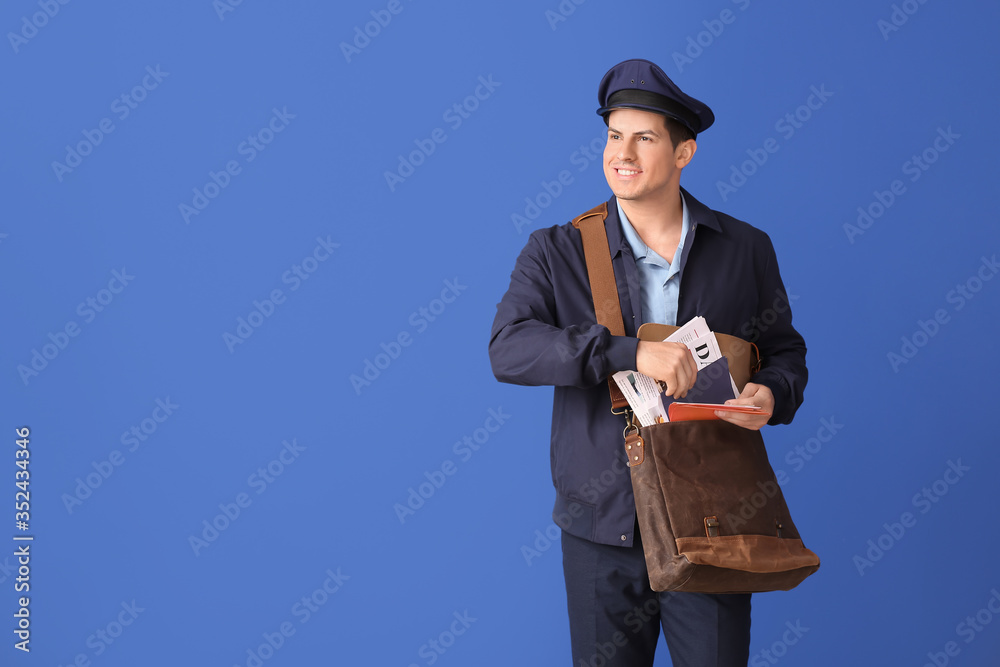 Handsome young postman on color background Stock Photo | Adobe Stock