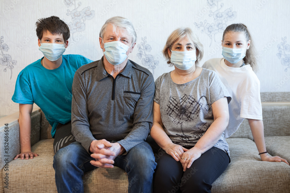 Family staying at home during coronavirus pandemic, wearing safety mask ...