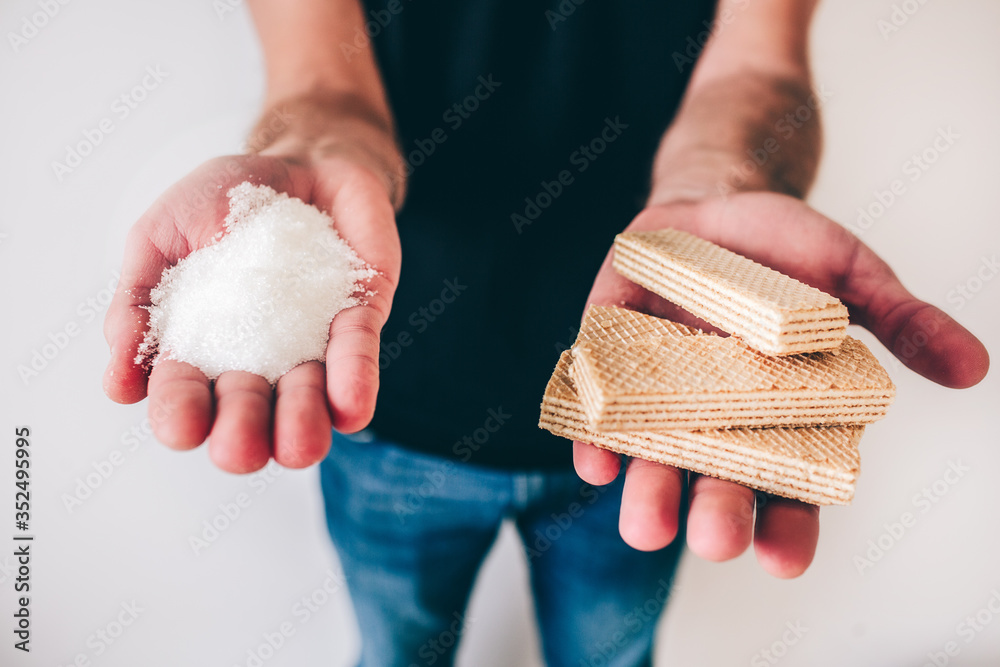 Young man isolated over white background. Guy hold crystal sugar in one ...
