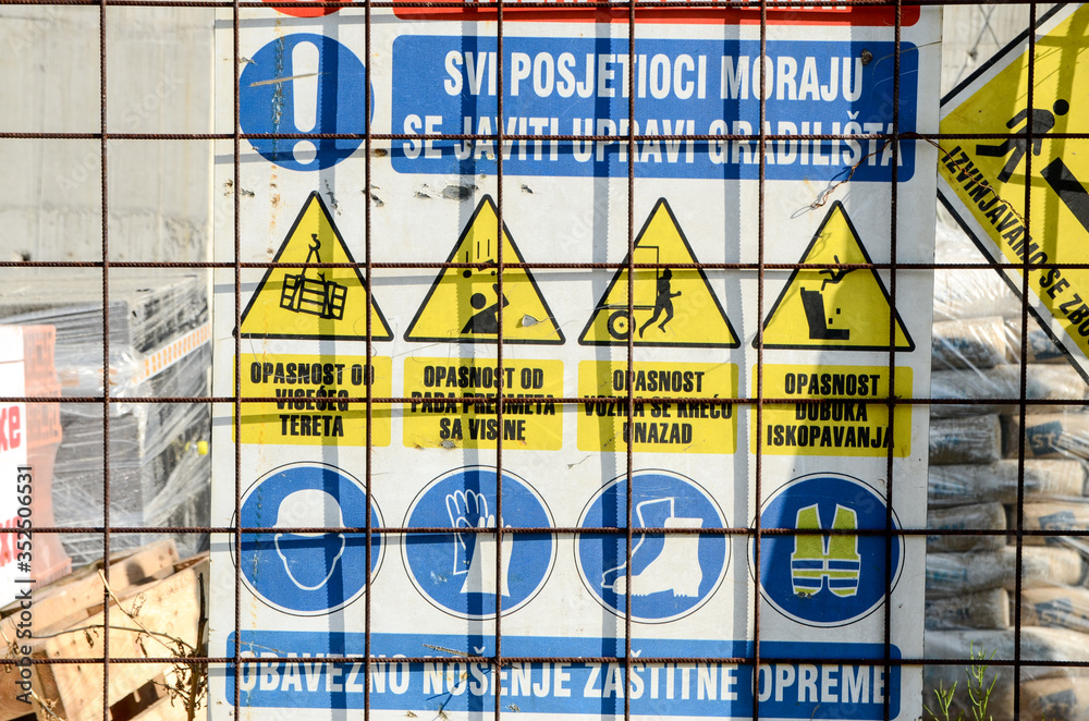 Warning signs on panel near construction site, close up. Symbol of ...