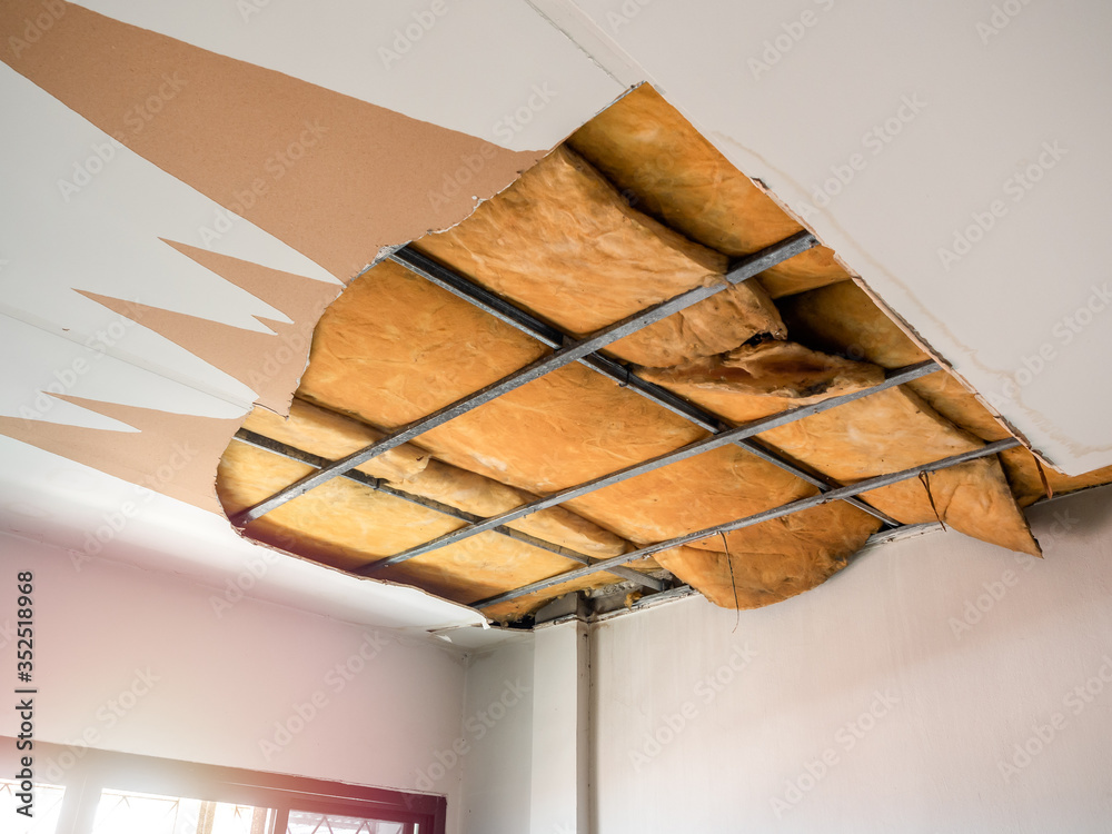 Broken ceiling. Destroyed white ceiling with visible structure inside ...