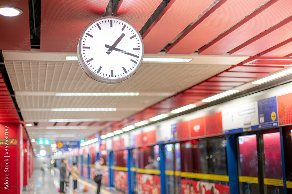 A classic white digital clock and escape exit sign hang from the ...