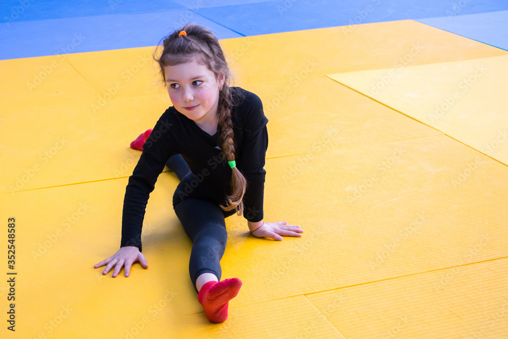 A schoolgirl takes part in dance competitions. Little girl is sitting ...