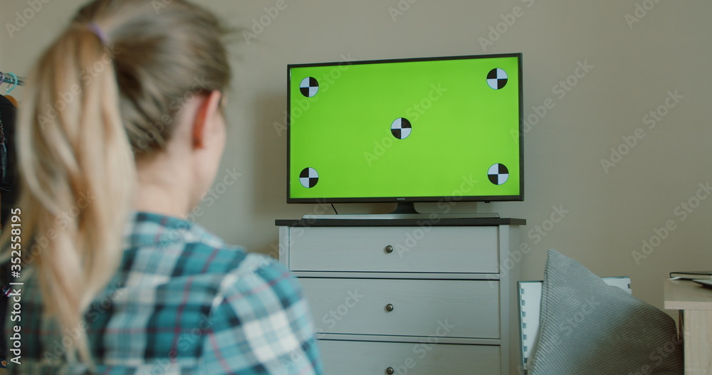 Television green screen, pretty girl watching modern TV at home and ...
