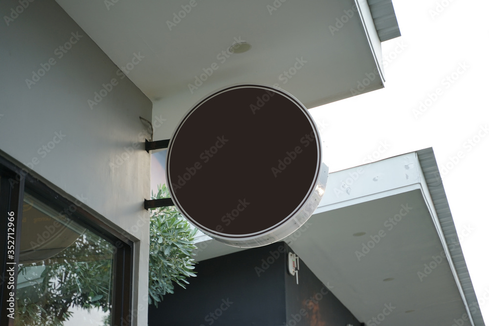 The circular billboard hangs on the front wall of the shop. Used to ...