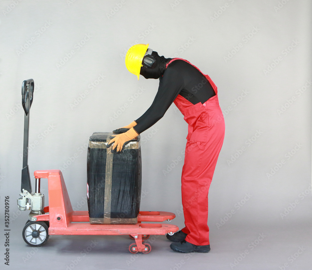 Anonymous worker dealing with heavy package at manual pallet truck ...