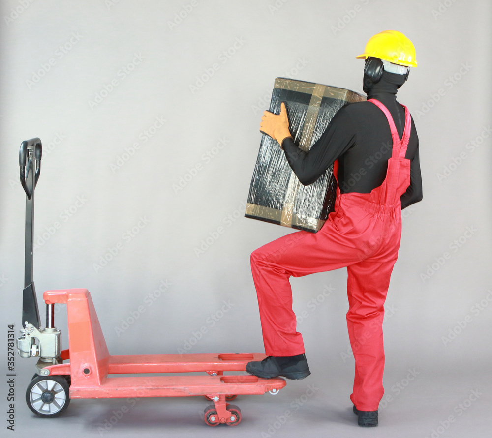 Anonymous worker dealing with heavy package at manual pallet truck ...
