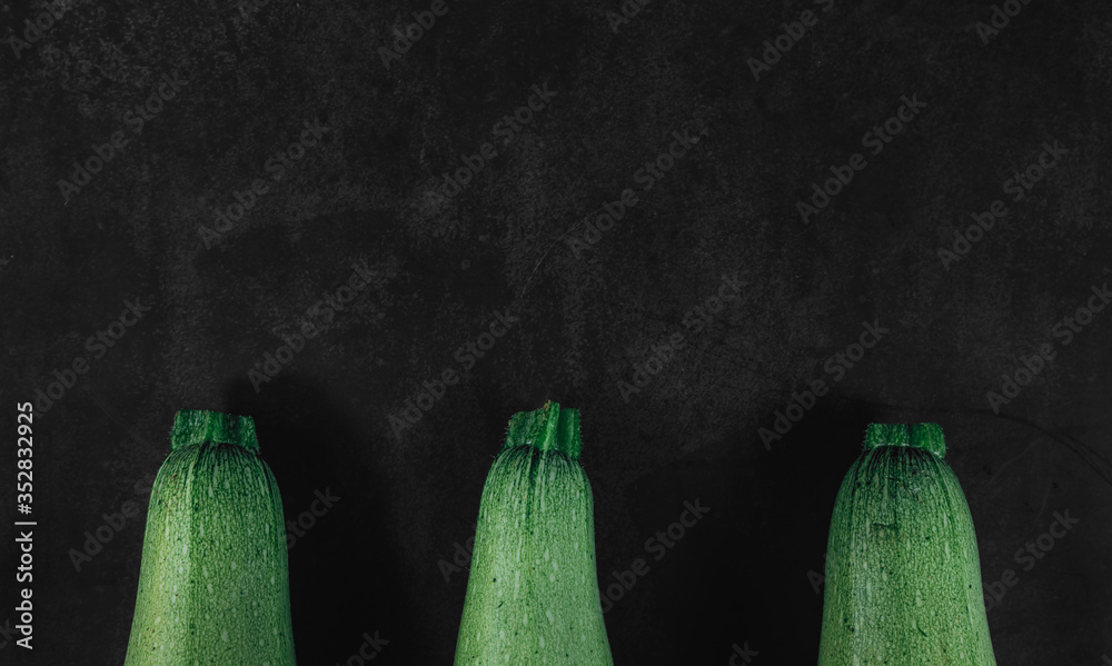 Parts of three green squash on a black background with space text ...