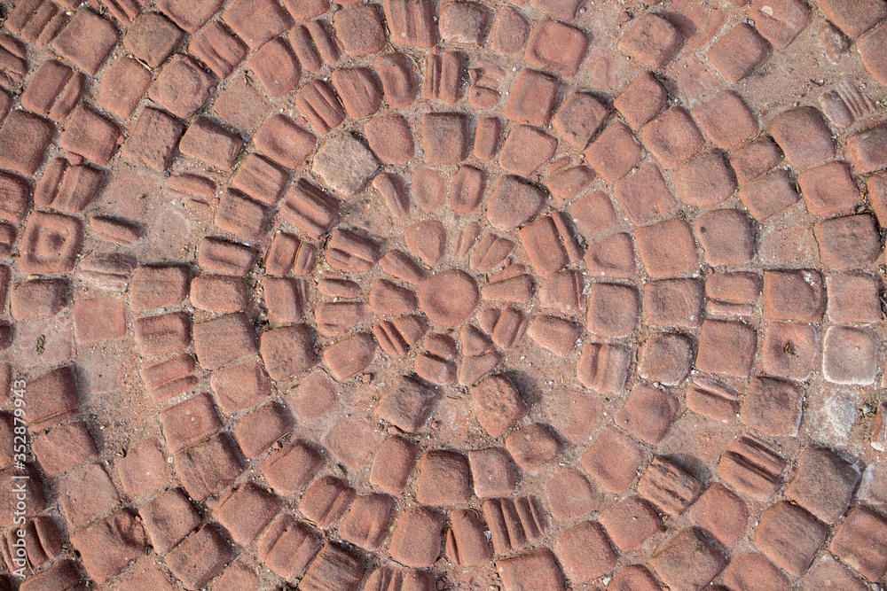 Old, red bricks arranged in a circle. Cobblestone. Texture, embossed ...