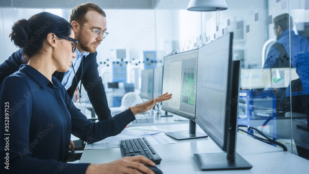 Modern Electronics Factory: Male Supervisor Talks to a Female ...