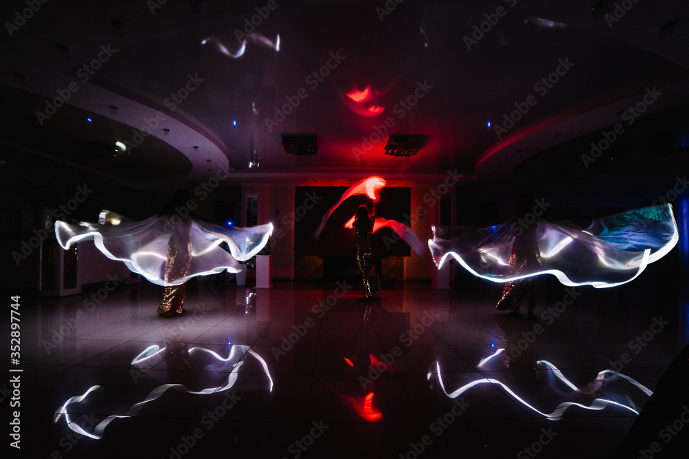 Dancers in suits with LED lamp, light show in movement, LED show in the ...