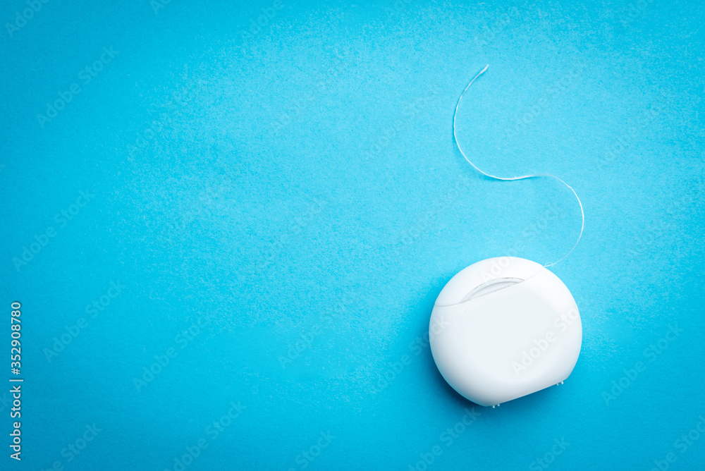 Dental floss on blue background. Stock Photo | Adobe Stock