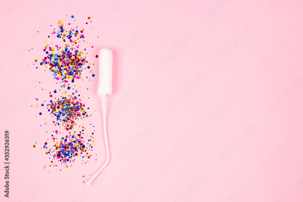 Clean cotton tampon with colorful sparkles on pink background with ...
