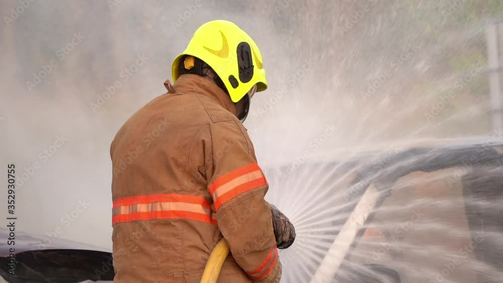 Slow motion/firefighters extinguishing the car caught on fire in a car ...