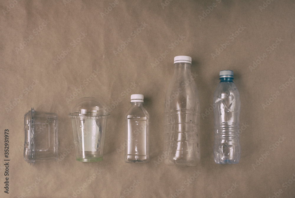 Various types of plastic food and water packaging on eco craft paper ...