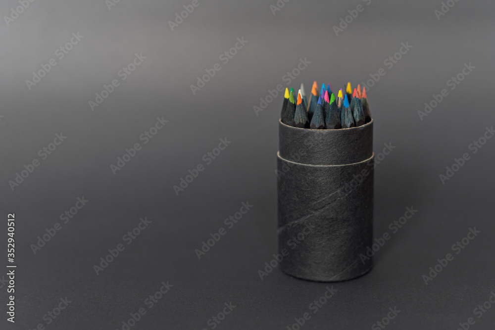 Black pencil holder box full of color pencils on dark background ...