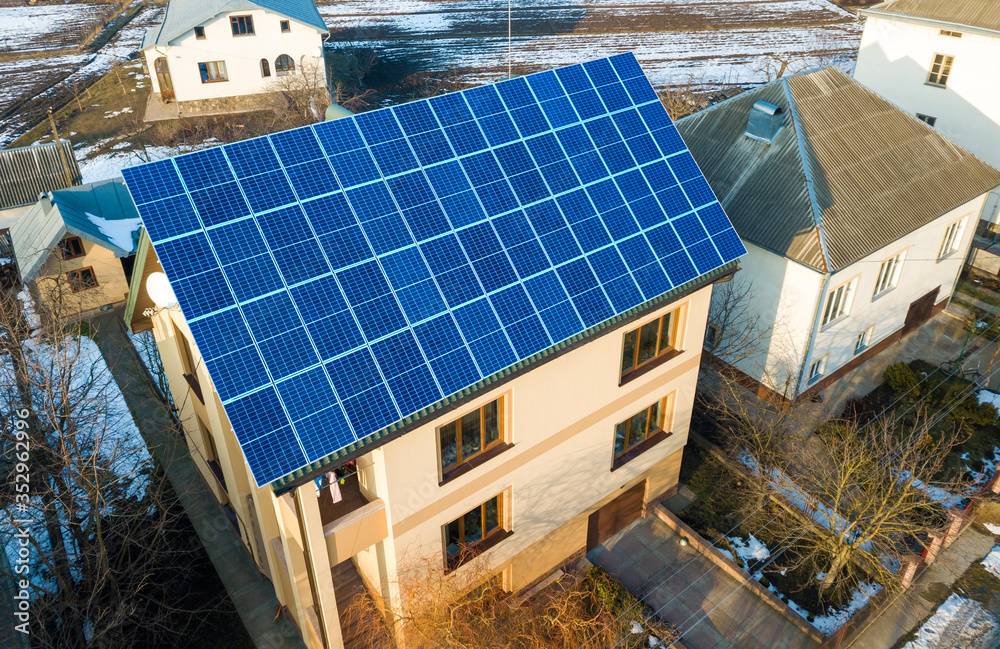Aerial view of new modern two story house cottage with blue shiny solar ...