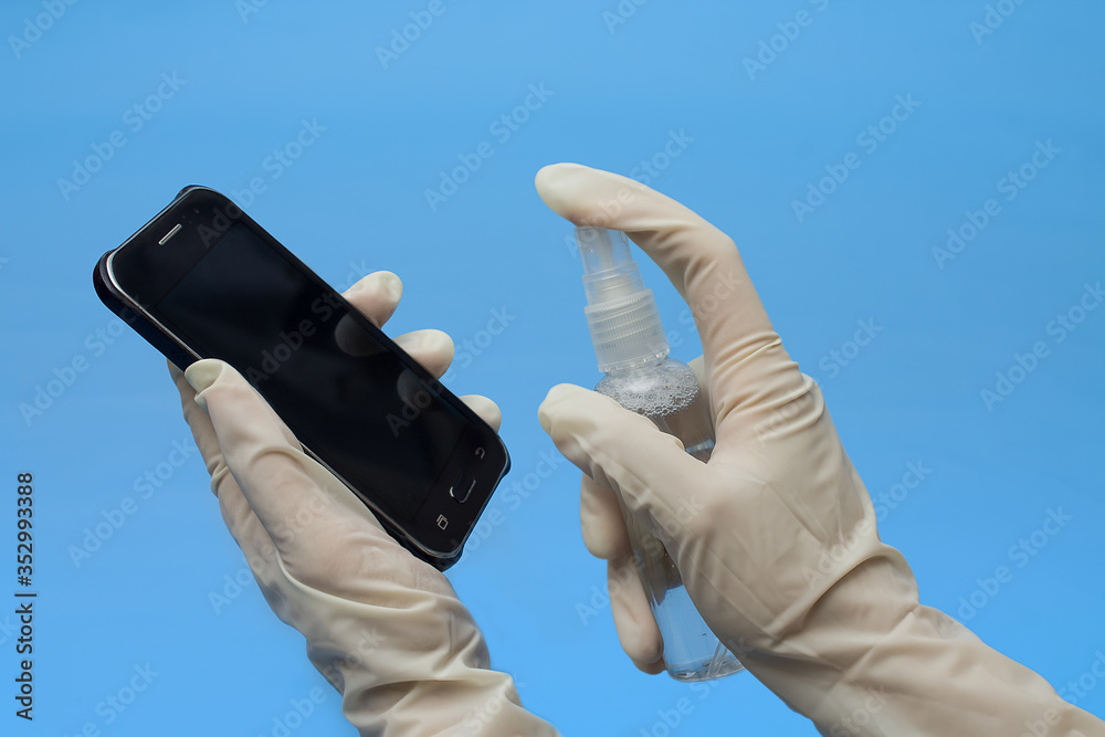 Hand disinfecting a cell phone with isopropyl alcohol and a microfiber ...