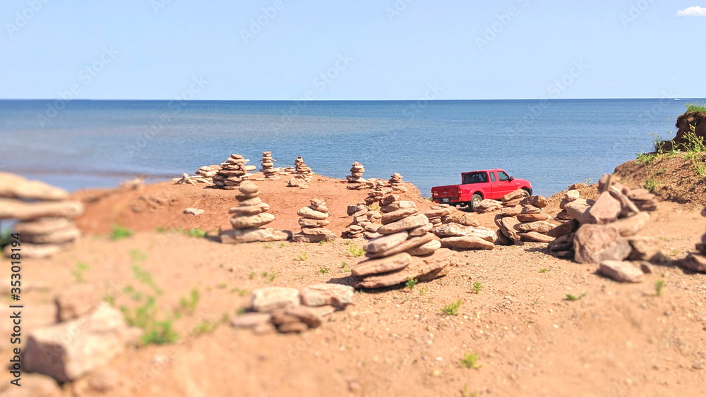A red pick up truck is parked on the red sand beach of North Cape, a ...