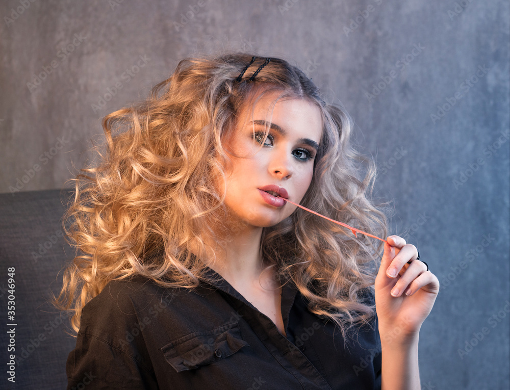 Portrait of a blonde girl with long and volume shiny wavy hair with ...