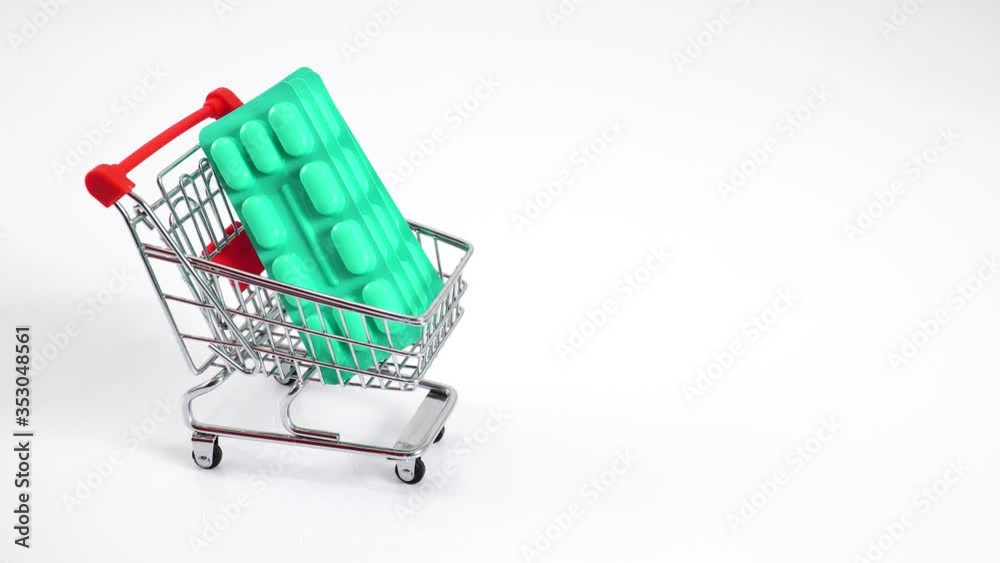 Hand pushing miniature toy supermarket trolley. There are several ...