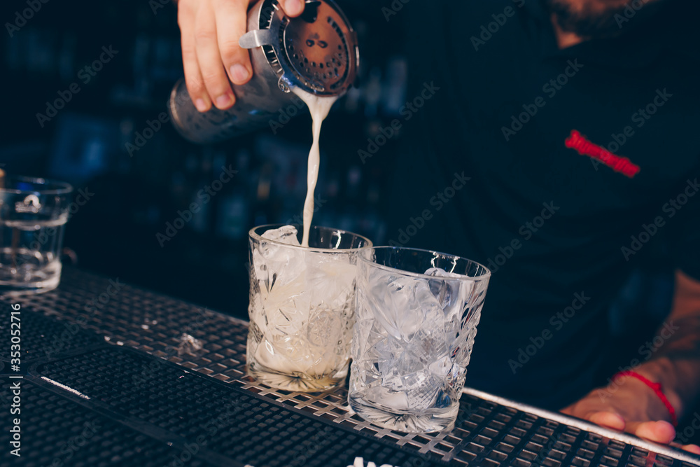 Bartender pouring using strainer White healthy Cocktail drink on a bar ...