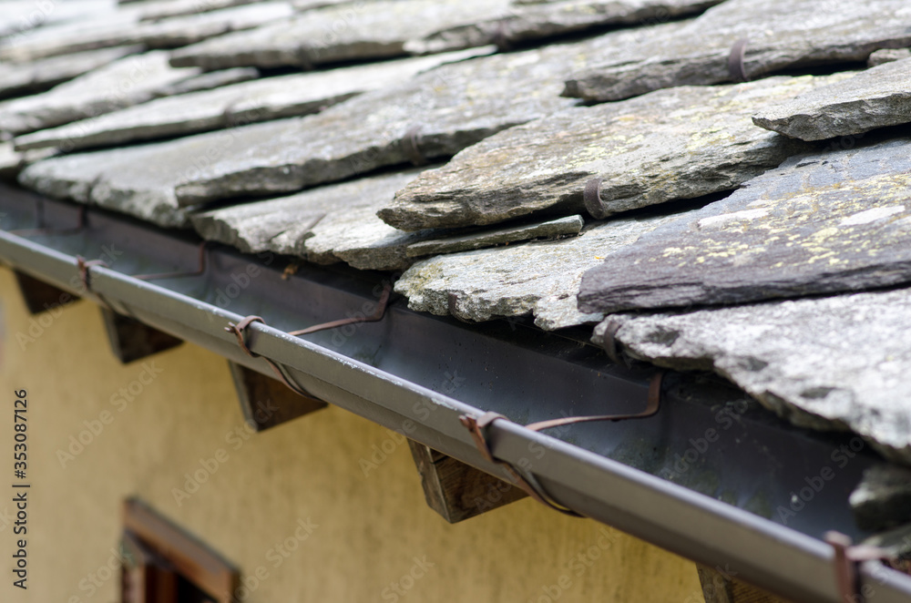 house with sloping pitched roof, particular texture with slabs of ...