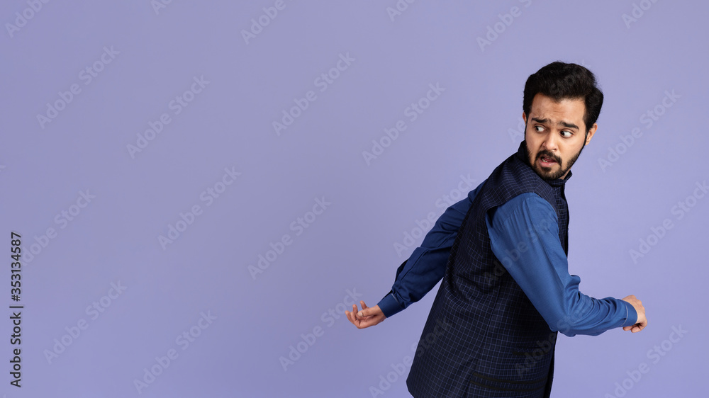 Scared Indian man running away from something on lilac background, copy ...