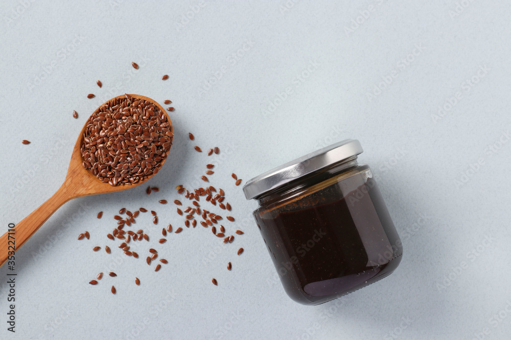 Vegan organic paste of flax seeds in glass jar and flax seeds in spoon ...