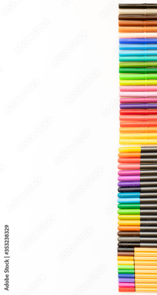 Set of markers of different colors arranged side by side, exactly on ...
