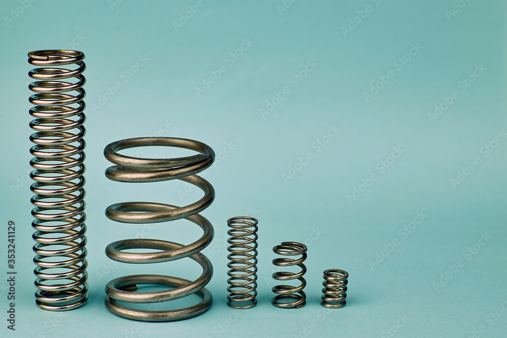 Springs of different sizes on a blue background. The different types of ...