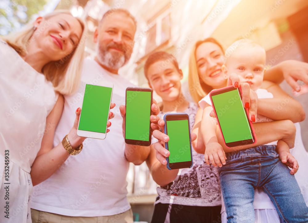 Foto de Portrait of a happy family showing smartphones screen when they ...
