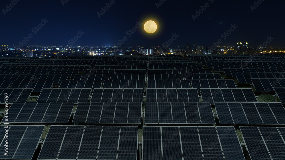Solar panels power plant at night with full moon and night city ...