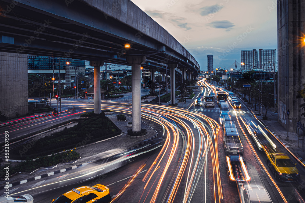 Car lights at evening on the road going to the city. Aerial view of the ...
