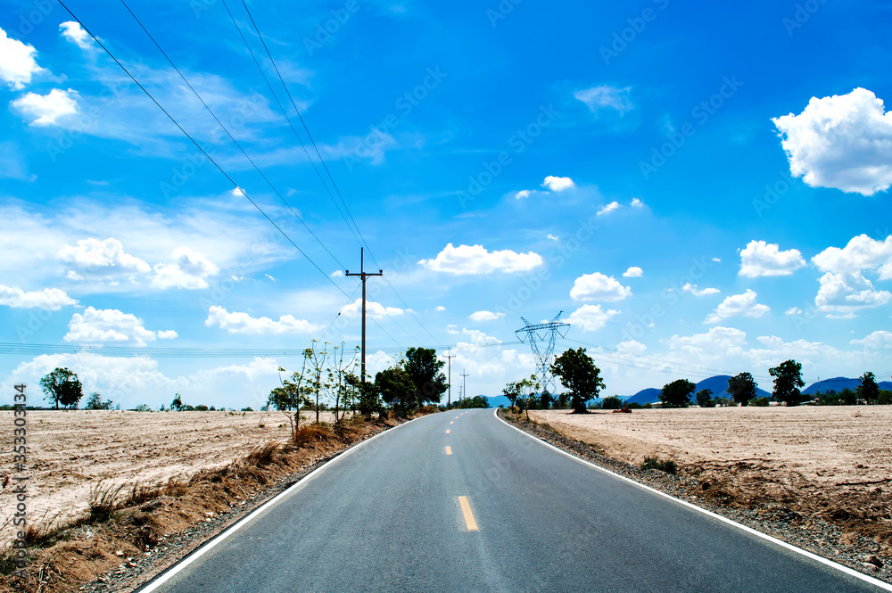asphalt road up to hill go to high voltage pole and white soil at ...
