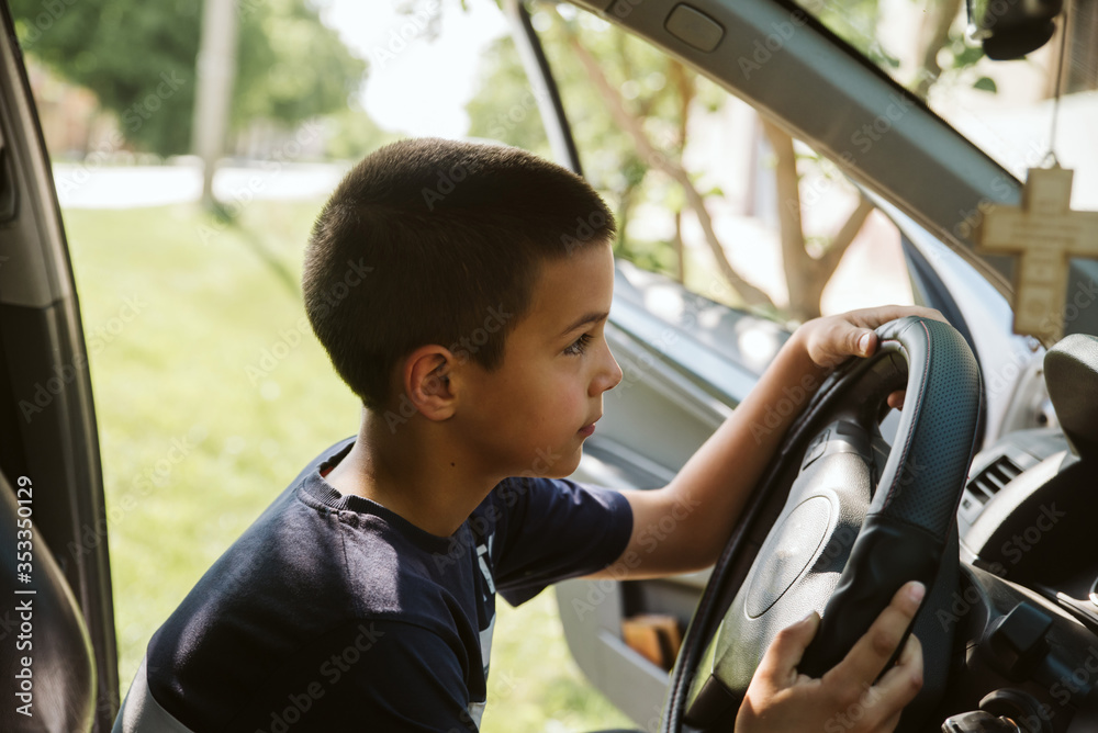 Little boy sitting in front of the car holding steering wheel 스톡 사진 ...
