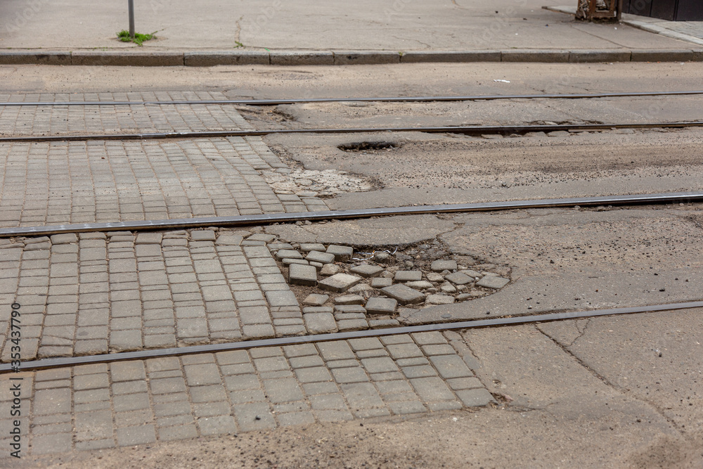 Damaged road with potholes, caused by freeze-thaw cycles in winter. Bad ...