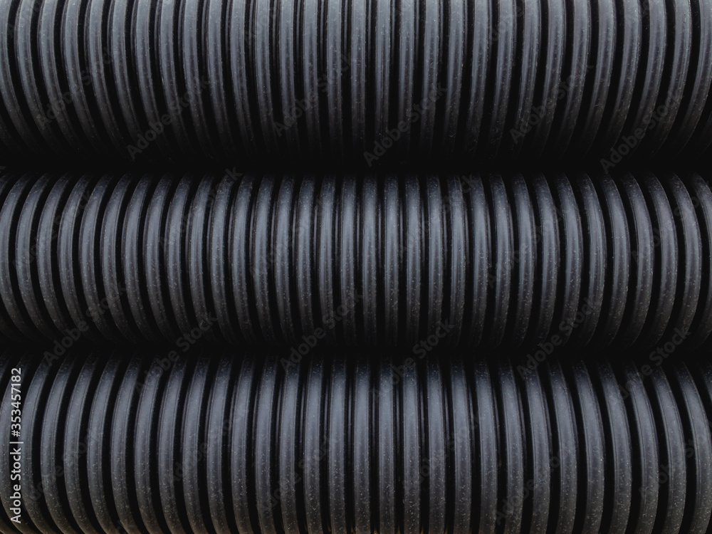 Black plastic corrugated pipes in natural light. Background image ...