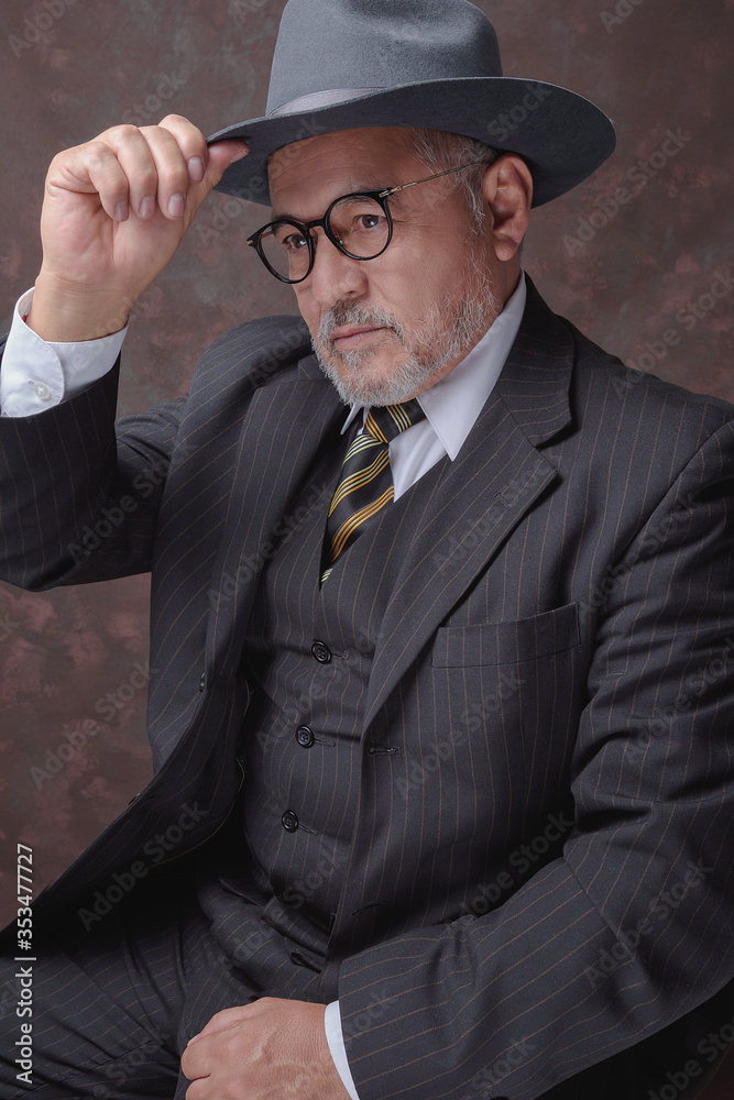 Señor maduro posando para la cámara con un traje de color café oscuro ...