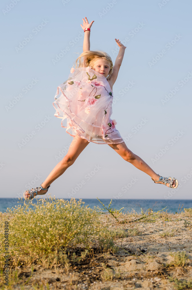 cute little girl in dress jumping up Stock Photo | Adobe Stock