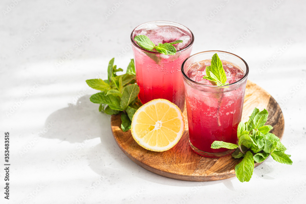Cold sparkling hibiscus or karkade tea with lemon, mint and ice in ...