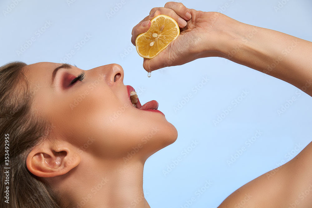Beautiful girl with lemon isolated on light studio background. Fashion ...