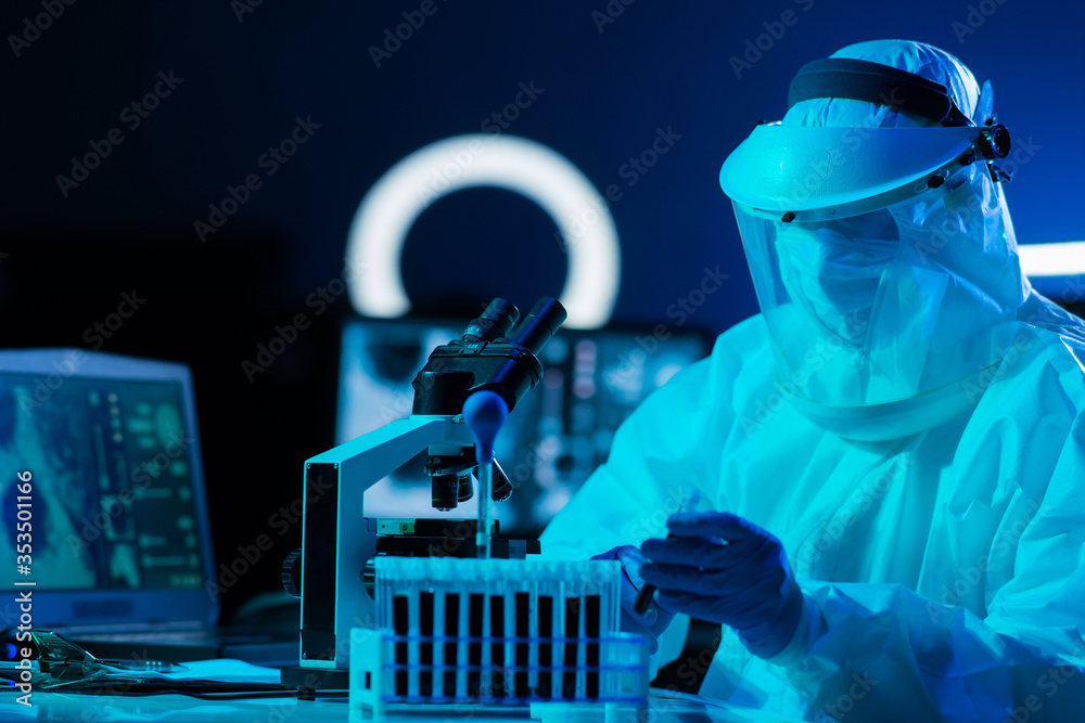 Scientist in protection suits and masks working in research lab using ...