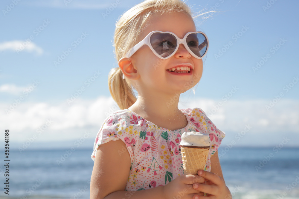 Adorable toddler girl eating ice cream. Portrait of child wearing ...