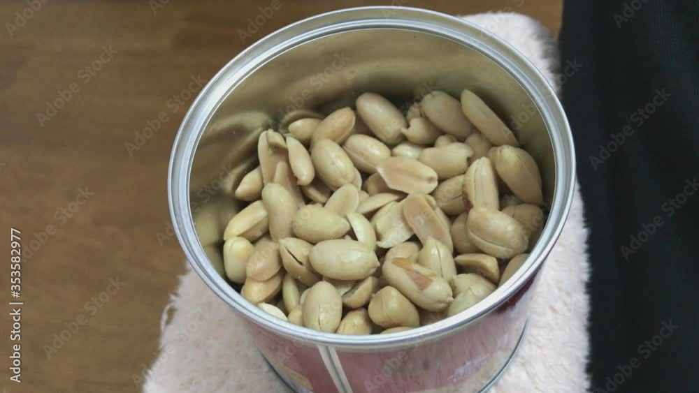 Adult pick salted peeled peanut from the can. Chinese traditional food ...