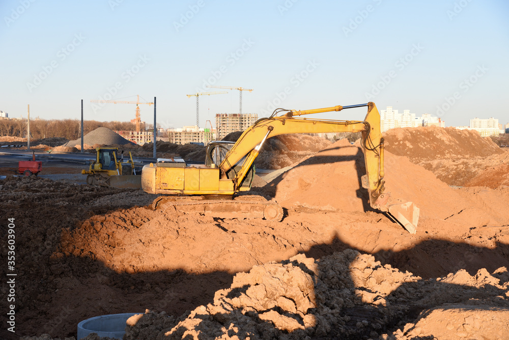 Excavator working at construction site on earthworks. Backhoe digs ...